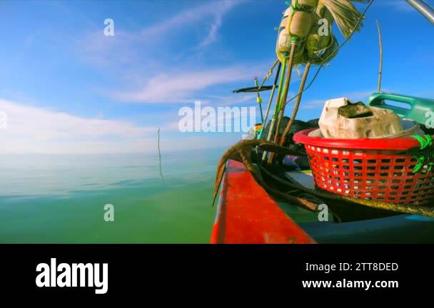 Wooden fishing boat in the sea with a big rusty anchor and some baskets ...