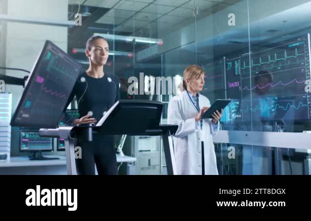 Woman Athlete Runs on a Treadmill with Electrodes Attached to Her Body ...