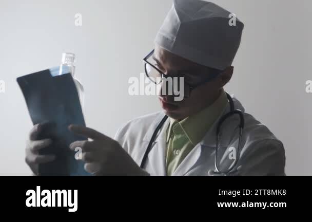 Drunk doctor makes a diagnosis. A medical worker drinks vodka Stock ...