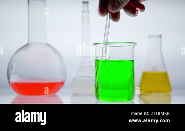 Different types of chemical laboratory glassware with liquids inside ...