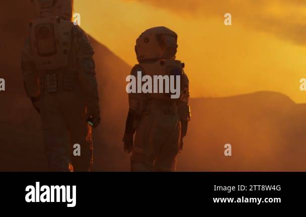 Back View of the Two Astronauts Wearing Space Suits Walk Exploring Mars ...