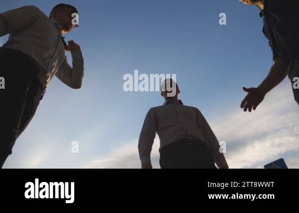 Three businessmen meeting and greeting each other in urban environment ...