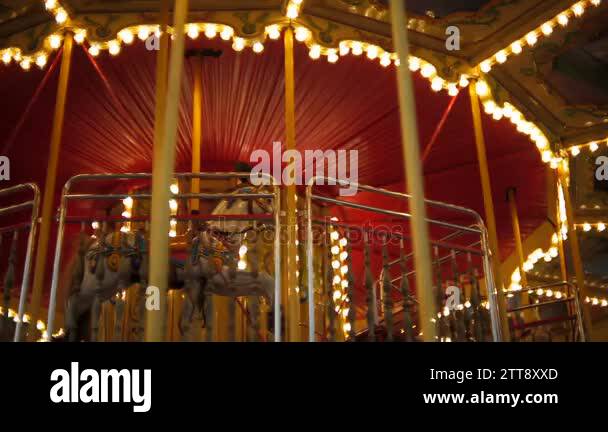 Illuminated merry-go-round carousel in amusement park at night Stock Video Footage - Alamy