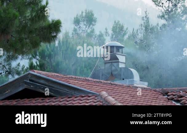 Smoke coming out of chimney on roof. Ventilation turbine is working ...