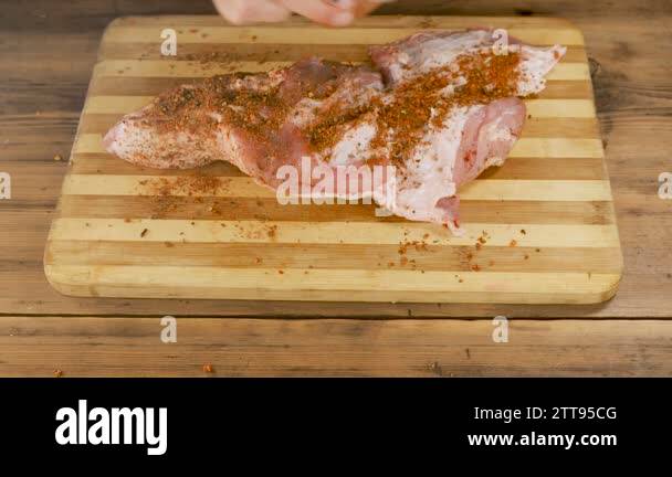 A man cooks meat on a cutting Board on the table from old wooden planks ...
