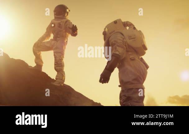 Two Astronauts Climbing Mountain Hill Helping Each Other, Reaching the ...