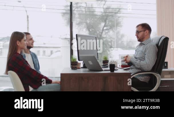 Young attractive couple have a conversation with their bank manager in ...