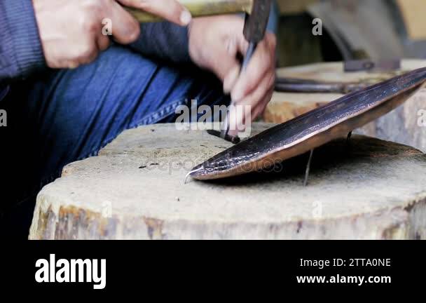 Traditional tinsmith work. Copper smith makes embossing artifacts from ...