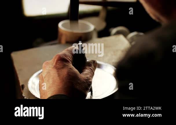 Traditional tinsmith work. Copper smith makes embossing artifacts from ...