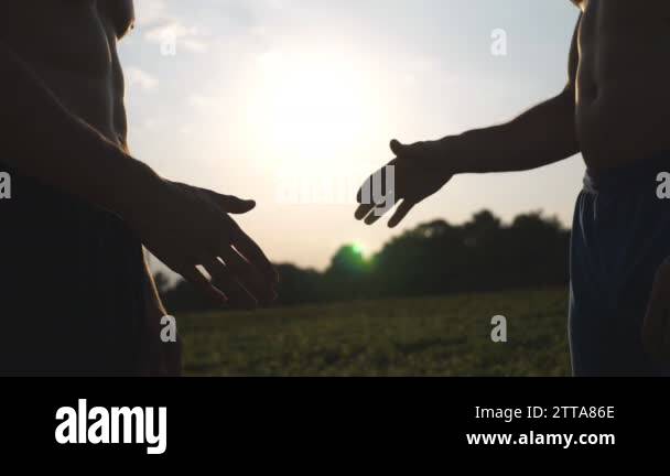 Friendly handshake of two unrecognizable muscular white men with sun ...