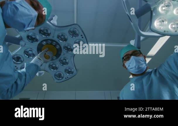 Low Angle Shot POV Patient View: Two Professional Surgeons Turning on ...