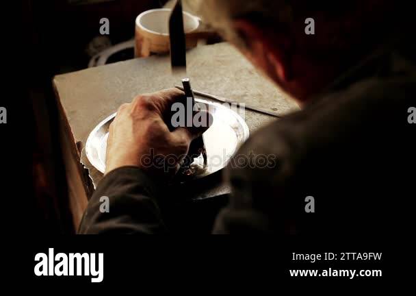 Traditional tinsmith work. Copper smith makes embossing artifacts from ...