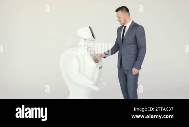 A stylish man communicates with a robot, presses a plastic mechanical ...