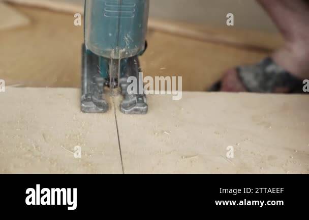 Working process of green dusty electric jigsaw cutting wooden plank ...