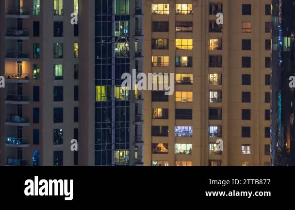 Glowing windows in multistory modern glass and metal residential ...