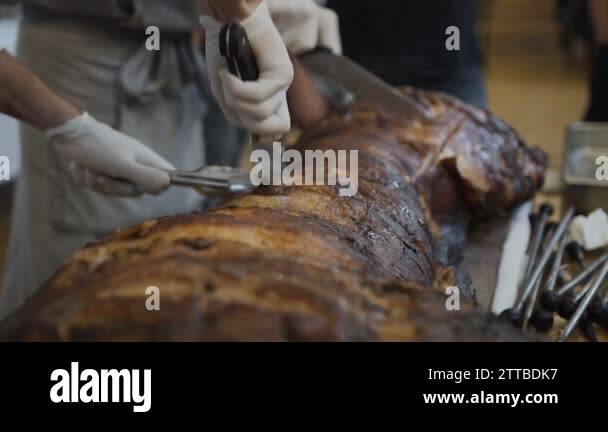 Chefs chop juicy meat of baked pork grill. Chefs hands with a knife ...