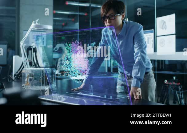 Asian Neural Network Engineer Uses Modern Computer With Transparent Holographic Display. Monitor ...