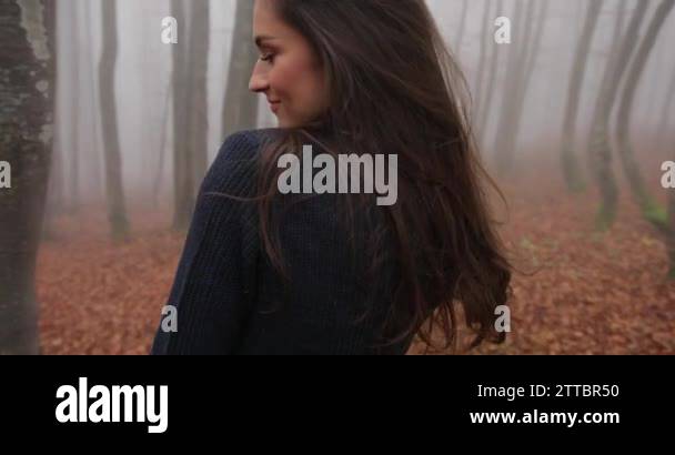 Autumn vibes, foggy forest. Attractive brunette woman with long hair ...