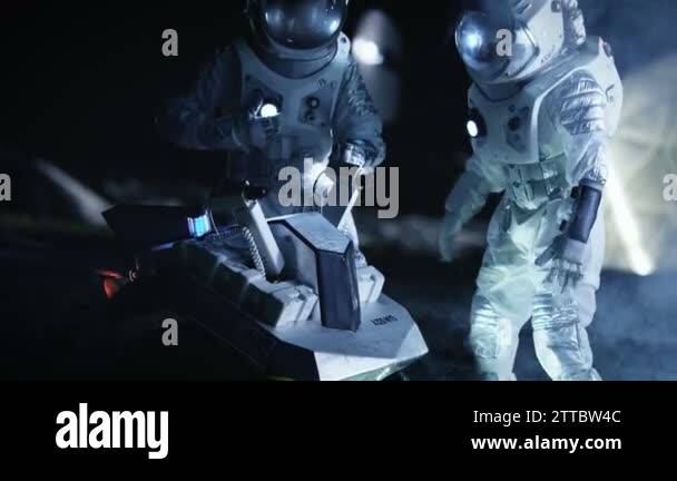 Two Astronauts in Space Suits on an Alien Planet Prepare Space Rover for Planet's Surface ...