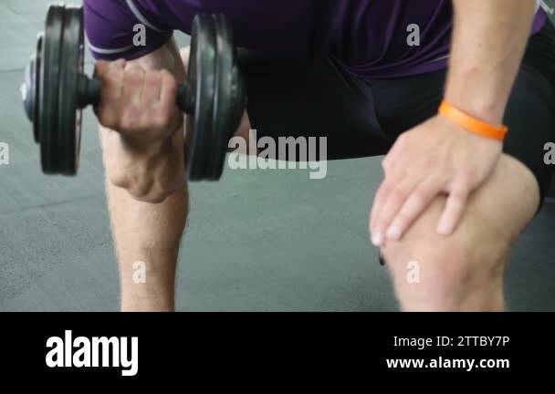 Man working his arms at the gym, He lifting the dumbbells and working ...