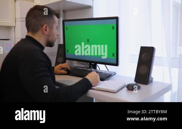Man using PC computer with green screen chroma key at home rewrite ...