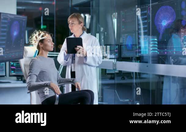 Woman Wearing Brainwave Scanning Headset Sits in a Chair while ...