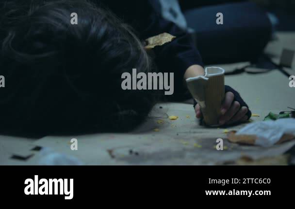 Drug intoxicated homeless woman sleeping on street full of garbage ...