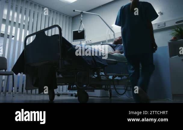 Low Level Shot in the Hospital, Very Sick Man Lying on the Bed, Nurse ...