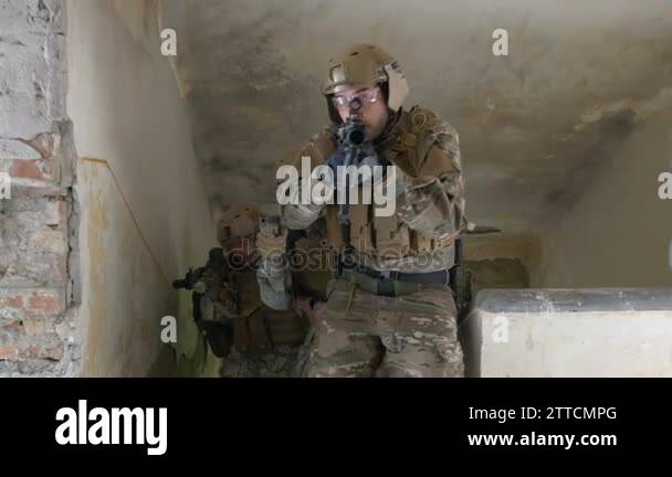 Trained soldiers searching floor to floor ruined building then descending stairs for exit Stock ...