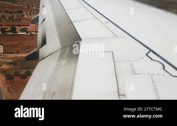 Wing view of aircraft flaps moving during windy landing. Athens ...