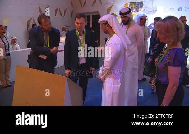 Arab man guide in hijab showing Arab pavilion stand for visitors people ...