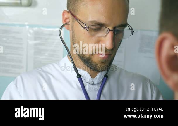 Portrait of handsome doctor examining patient with stethoscope. Young ...