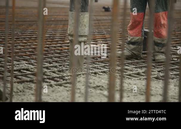 Pouring concrete mix from cement mixer on concreting formwork. Finished ...