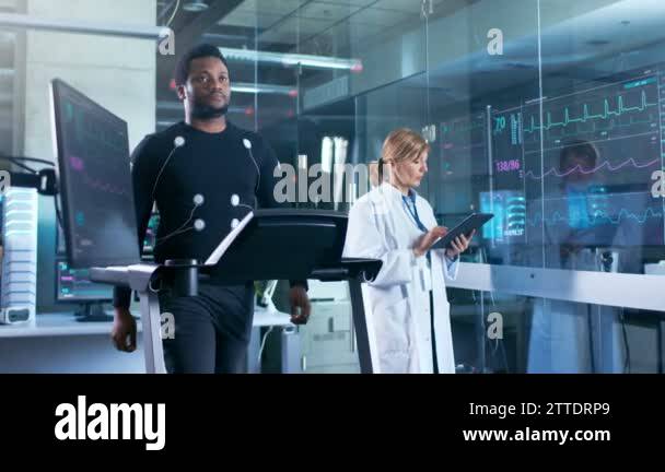 Male Athlete Walks on a Treadmill with Electrodes Attached to His Body ...