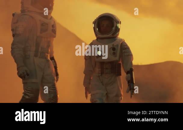 Two Astronauts Wearing Space Suits Walk Exploring Mars/ Red Planet. Space Travel, Exploration ...
