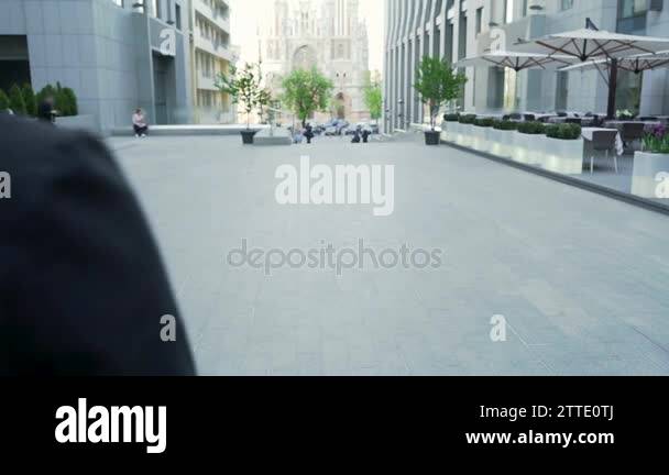 Lady boss walking down business center followed by male assistant, back ...