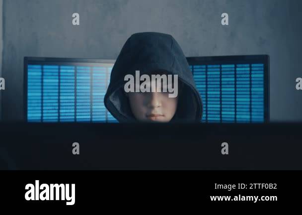 Portrait of a Genius Boy Hacker Prodigy in the hood working on computer ...