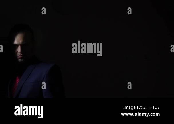 Man pulling out his gun in the darkness and aiming at the camera. 4k ...