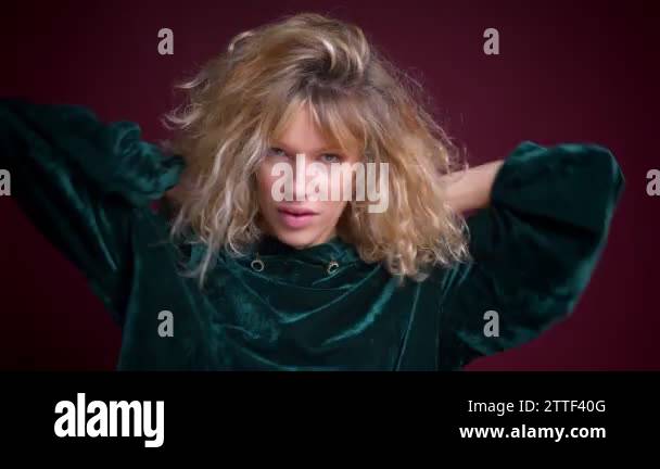 Closeup portrait of young stunning model tossing her blond hair and ...