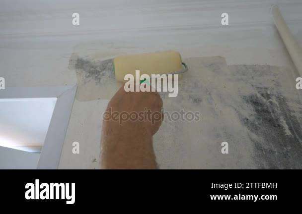 applying Wallpaper paste to the wall with a roller,preparation for ...