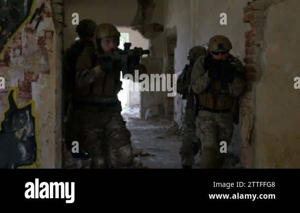 Group of soldiers moving fast through ruined building in search and ...