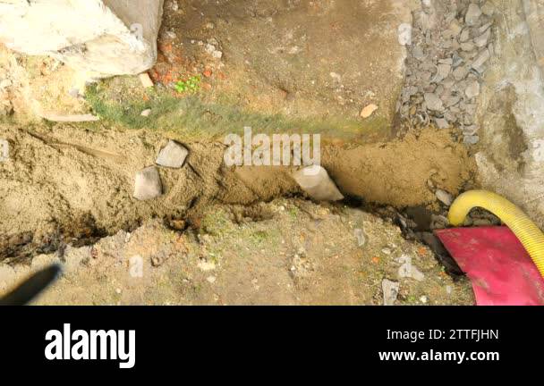 Pouring, laying concrete into foundations of the house using shovel of ...