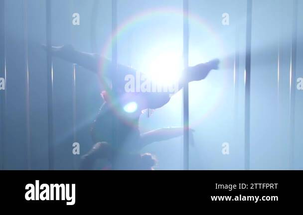 Acrobatic gymnast performance on a spinning hoop in a cage on the stage ...