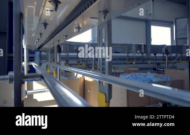 Empty water bottles transferred through a long guide rail in fast ...