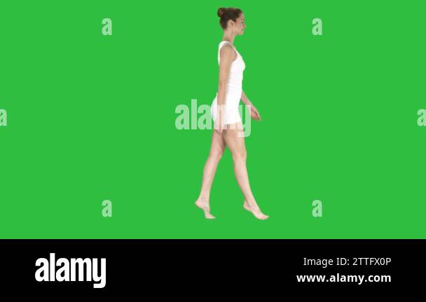 Full length side view. The young woman walking on her tip-toes on a ...