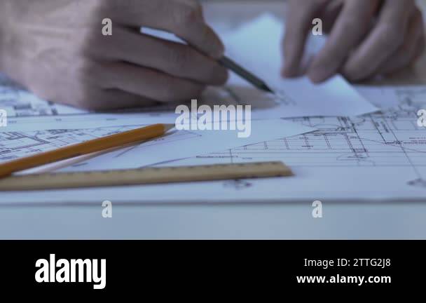Architect checking building guidelines drawing, design bureau, hands ...