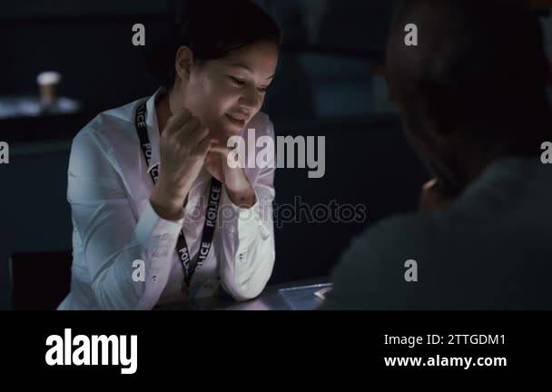 4K Female police detective questioning a crime suspect and showing him ...