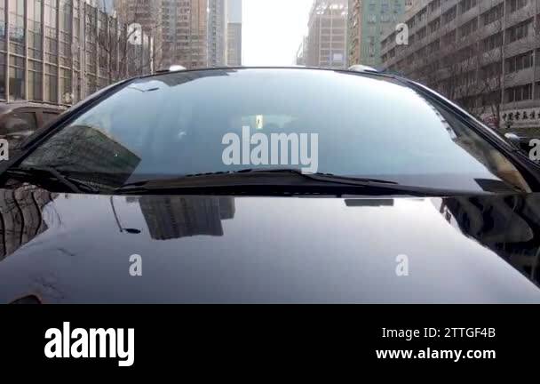 Camera mounted on car hood facing window, driving through a city ...