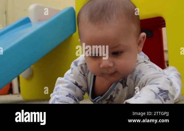 cute baby boy having tummy time outside while his older brother is ...