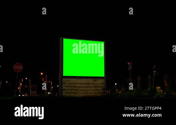 Empty billboard with chroma key green screen at night. Street lights ...